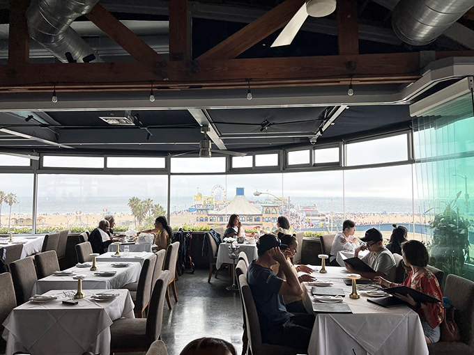 The dining room at golden hour – where strangers become united in the universal language of "wow" as Santa Monica Pier glows in the distance.