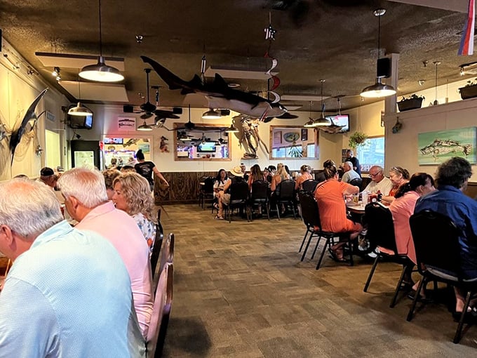 A full house of happy diners under watchful mounted fish—like a seafood summit where everyone's agreed on the perfect meeting place.