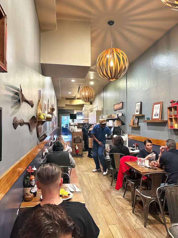 The narrow dining room creates an intimate experience where strangers become temporary breakfast companions. Those wooden spherical lights could double as art installations. 