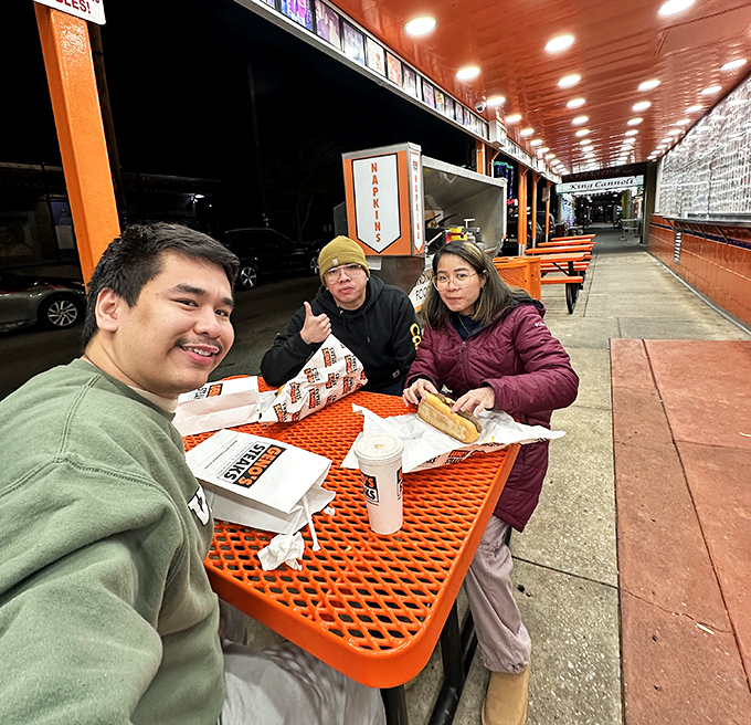 Late-night pilgrims at the altar of cheesesteak. Their expressions say it all: worth every minute in line.