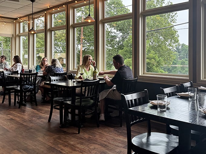 The dining room buzzes with the universal language of good food and conversation, framed by nature's own artwork through those magnificent windows.