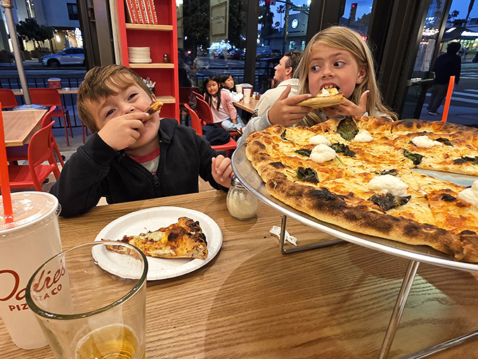 Family pizza night in full swing, where the only thing better than the pies is watching kids experience their first taste of proper pizza enlightenment.