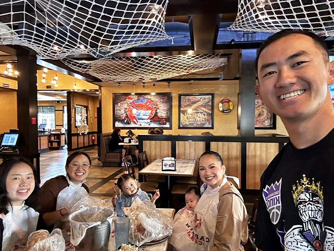Happy families gathering around plastic bags of seafood&mdash;proof that the best dining experiences aren't about white tablecloths but shared moments of discovery.