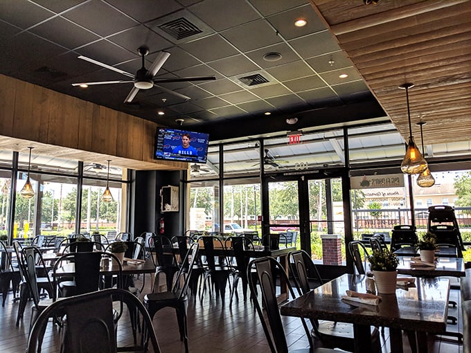 The dining area balances modern industrial elements with warmth. Those large windows let in natural light that makes the food look even better.