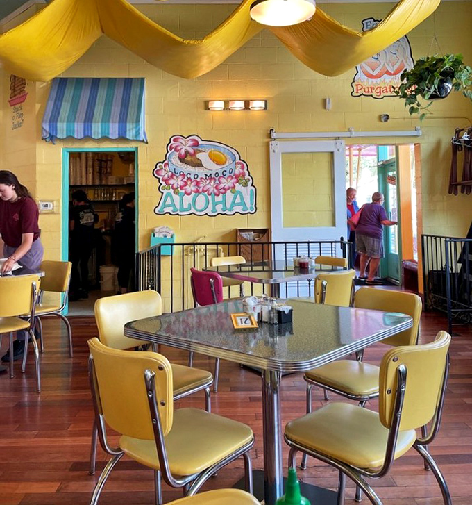 Retro diner dreams come true with "Aloha" vibes. Those yellow chairs aren't just seating &ndash; they're time machines to a more colorful era.
