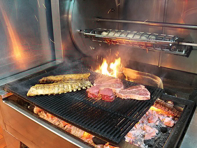 Where the magic happens: flames leap as prime cuts sizzle on the wood-fired grill, a primal cooking method that elevates everything it touches.