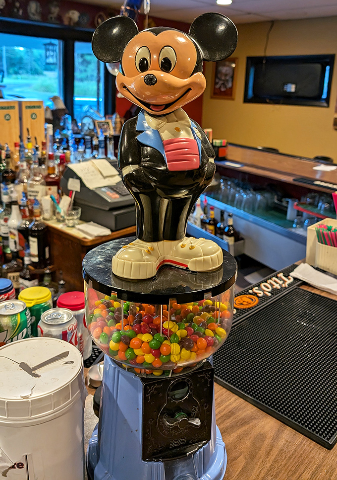 Mickey guards the gumball machine like a whimsical sentinel of childhood joy&mdash;a touch of playfulness amid serious dining.