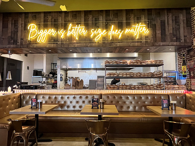 "Bigger is better, size does matter" proclaims the neon truth above the open kitchen. The tufted leather booths below silently agree.