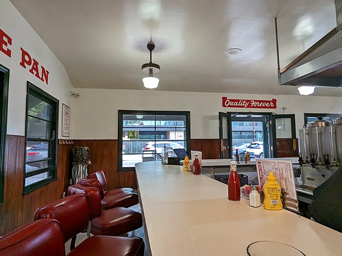 The counter view&mdash;where burger dreams come true. That wood paneling has absorbed enough happy sighs to power a small city. 