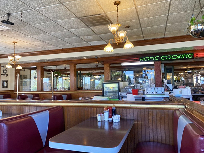 Classic diner geometry &ndash; booths designed for lingering conversations, hanging plants that soften the space, and lighting that flatters everyone.