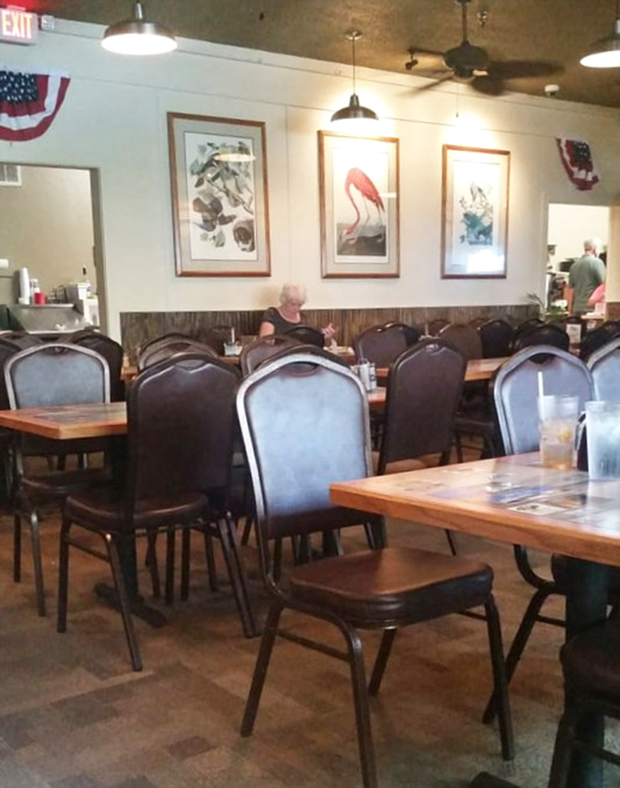 Framed coastal art and comfortable seating create the perfect backdrop for breakfast conversations. The American flags remind you this is patriotic eating.