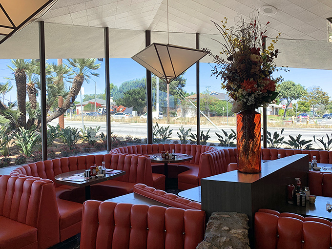 These curved booths create little islands of privacy in a sea of conversation, where sunlight streams through windows that have framed decades of LA mornings.