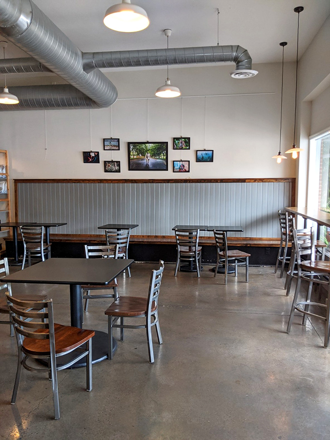 Empty tables that won't stay that way for long, with industrial pendant lights hanging like promises of good meals to come.