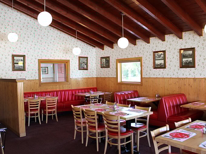 Red booths, wood paneling, and cherry-patterned wallpaper &ndash; dining room design by way of 1965, and we wouldn't have it any other way.