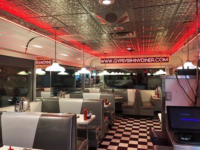 The evening glow transforms The Shiny Diner into a neon-lit sanctuary where the pressed tin ceiling reflects decades of good times and better meals.