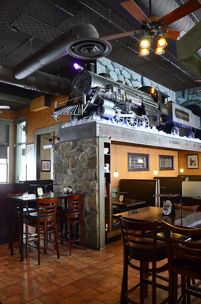 That model train watching over diners is a reminder: good things come to those who wait for properly cooked pizza.