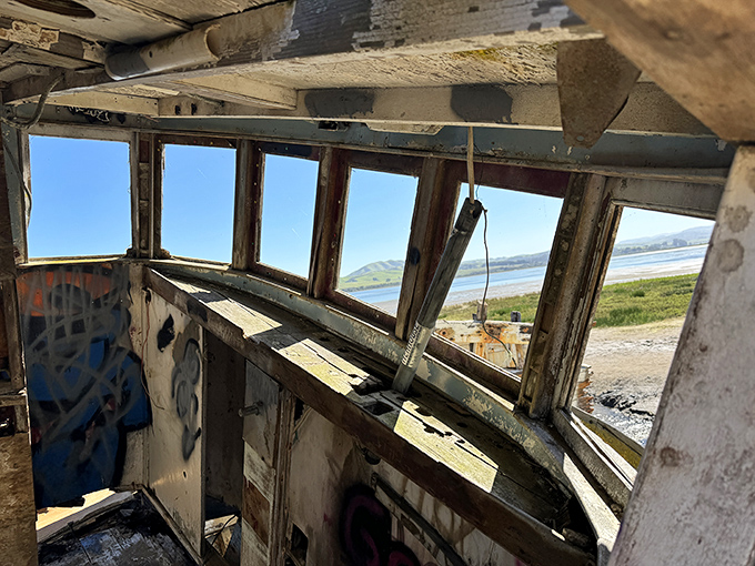 Windows to nowhere frame the very bay this vessel once navigated. Time's passage captured in weathered wood and endless blue.