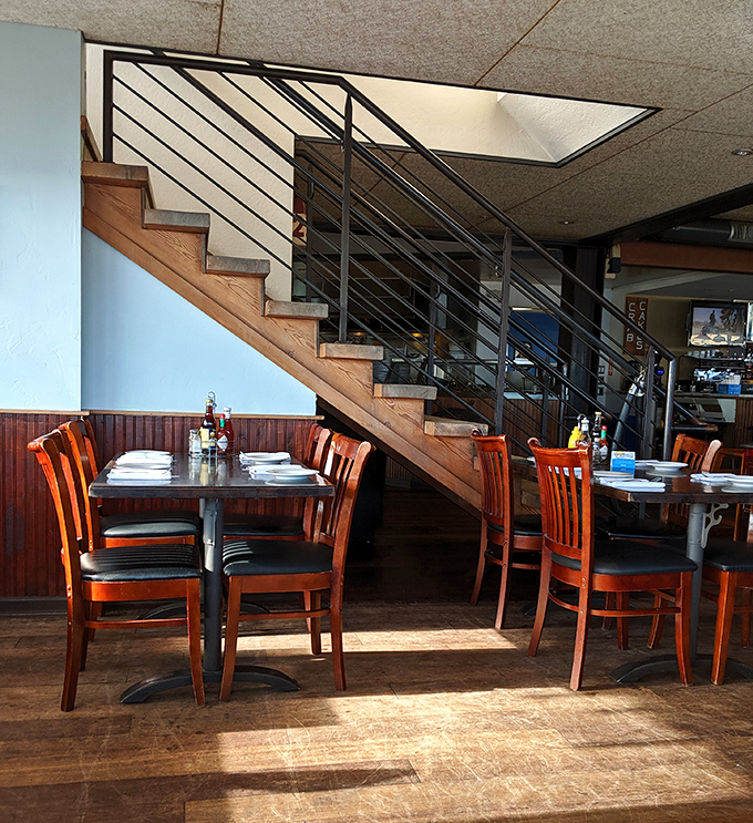 The interior's wooden staircase and warm lighting create that rare "fancy but comfortable" vibe where both flip-flops and dress shoes feel at home.
