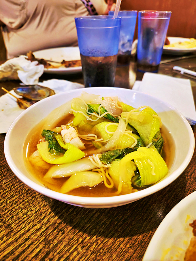 A steaming bowl of Asian-inspired soup with fresh bok choy and noodles. The perfect palate cleanser between trips to the crab leg station.