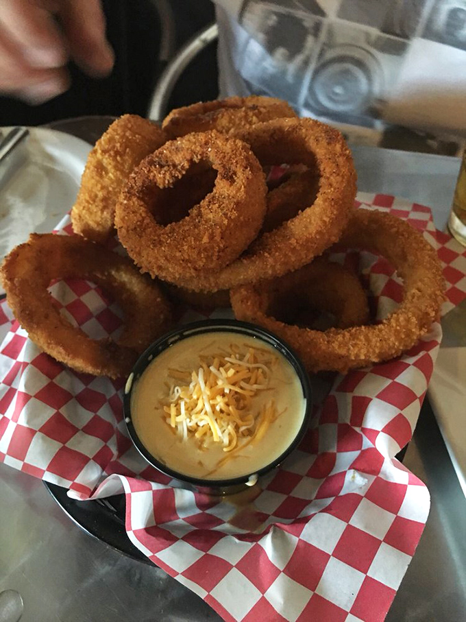 Golden-brown onion rings stacked like delicious jewelry, with cheese sauce that's basically liquid gold. Crispy outside, tender inside—the textural promised land.
