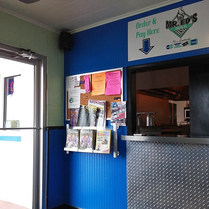 The ordering counter, complete with local newspapers and community flyers, serves as both food gateway and small-town bulletin board.