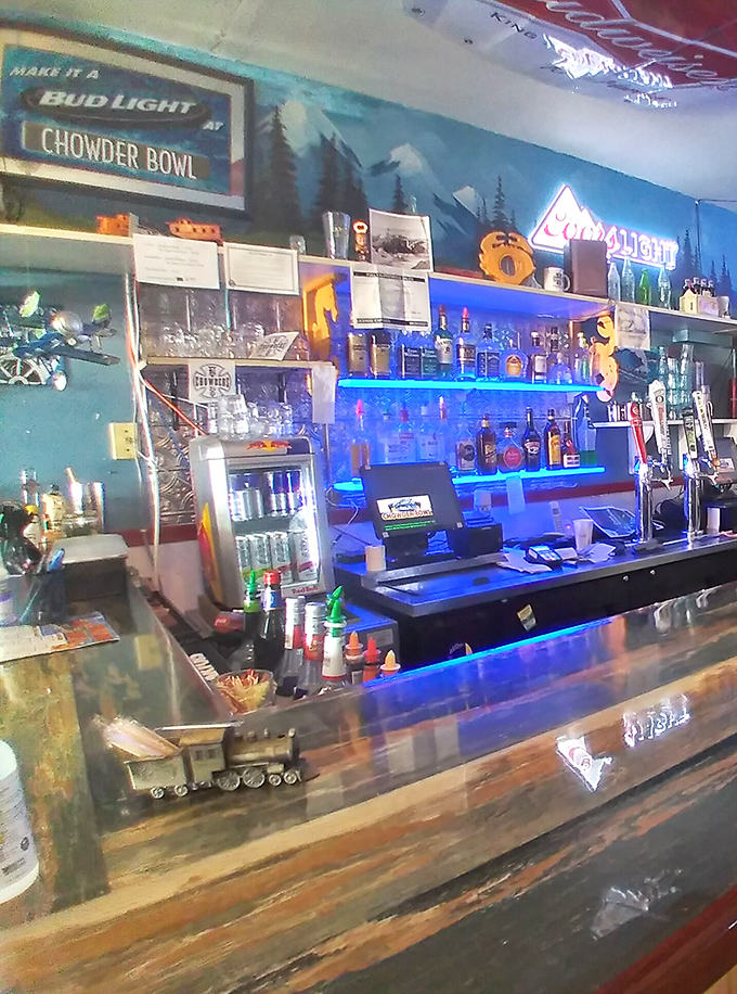 The bar area glows with neon signs and coastal charm&mdash;where locals and tourists alike gather to toast the day's adventures.