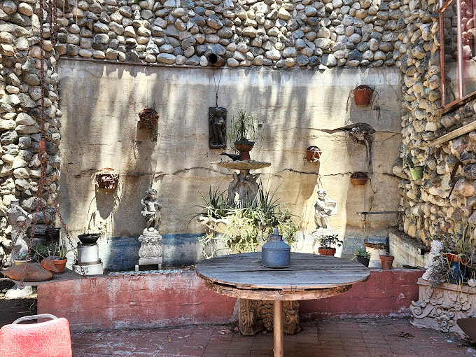 A quiet courtyard oasis where river rocks meet garden charm. The perfect spot to contemplate how one person's "junk" becomes another's architectural masterpiece.