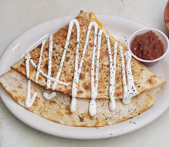 A quesadilla wearing its sour cream and salsa like a fancy hat at the Kentucky Derby.