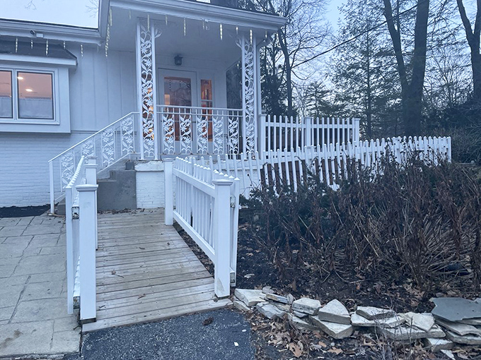 The charming white railing and entrance ramp welcome you like an old friend, promising good things for those who cross this threshold.