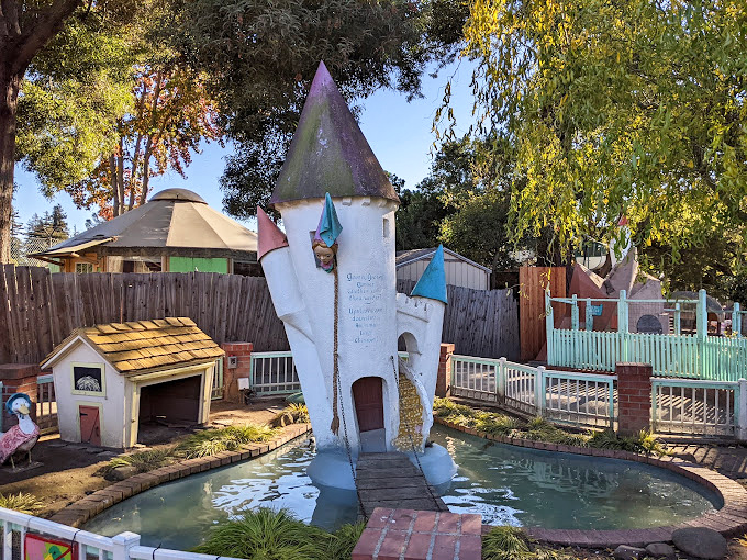 Rapunzel's tower stands beside a tranquil pond, proving that even fairy tale princesses appreciate waterfront property.