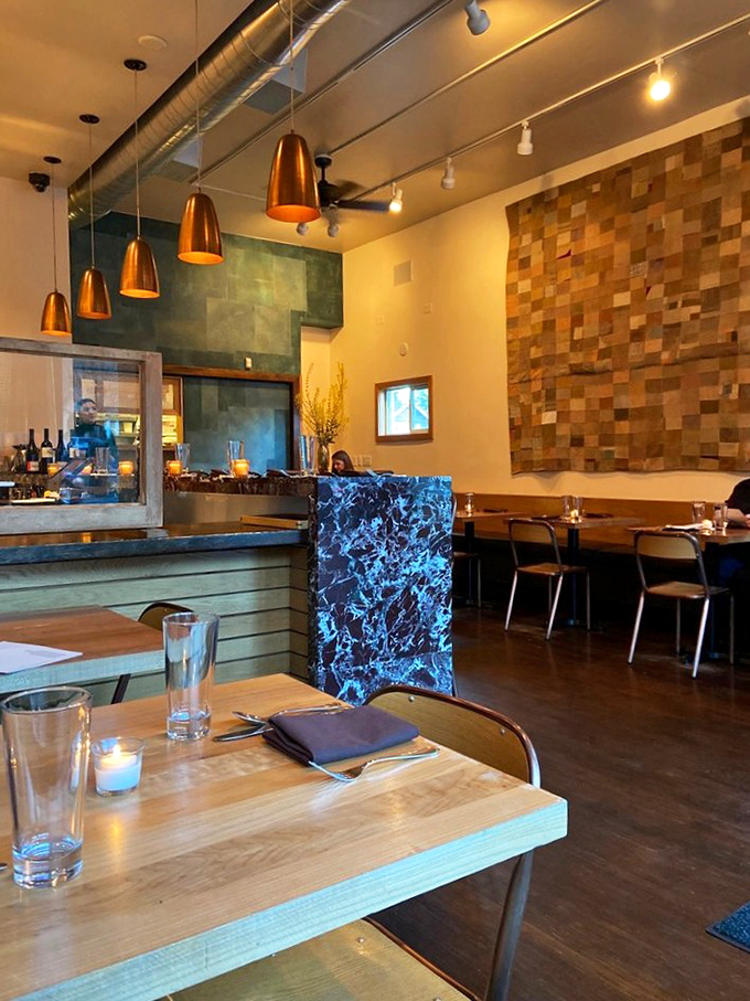 The dining room feels like the living room of that friend who's mysteriously good at everything. Warm woods, textured walls, and not a bad seat in the house.