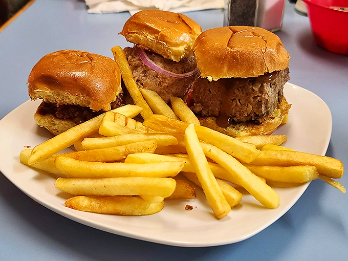 Three perfectly proportioned sliders standing at attention next to golden fries&mdash;proof that good things really do come in small packages.