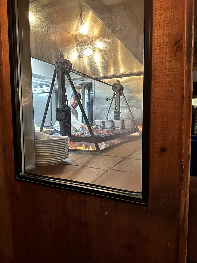 Through this window, witness the sacred ritual of oak-fire cooking, where skilled hands transform raw ingredients into memorable meals.