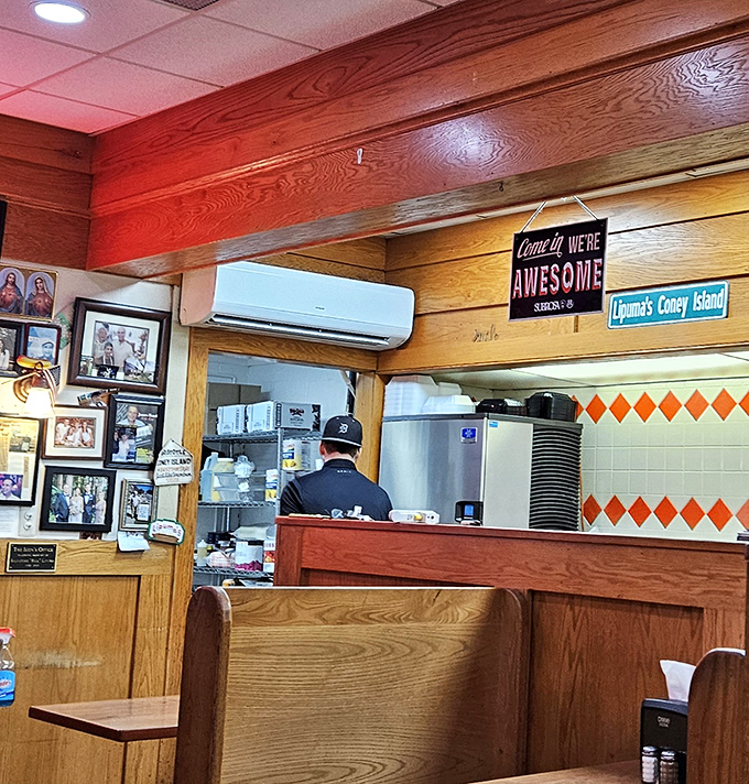 Where the magic happens! The open kitchen design lets you watch hot dog artistry in action, with decades of community photos lining the wooden walls.
