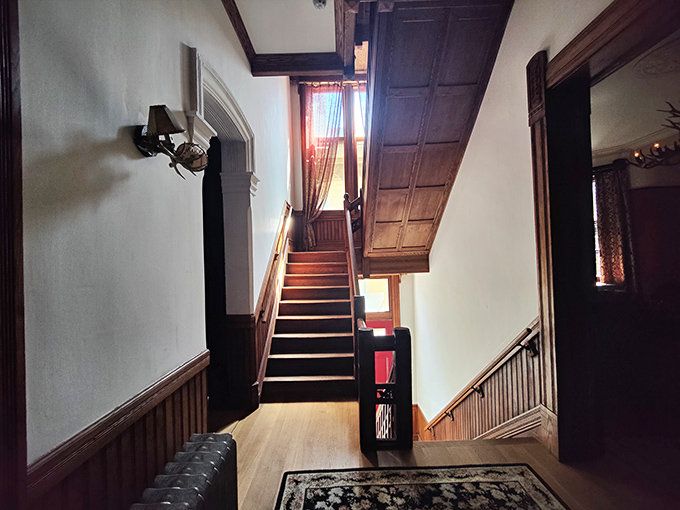 These wooden stairs have carried countless footsteps over more than a century. The warm wood tones contrast beautifully with the white walls.
