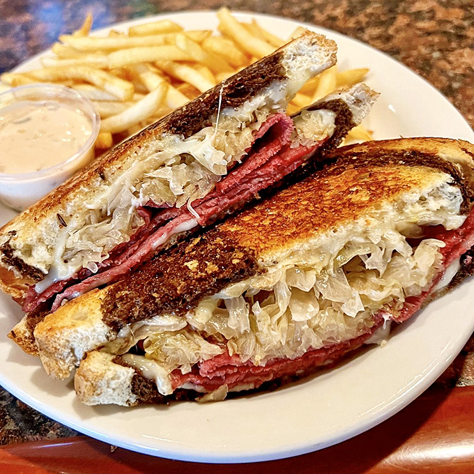A Reuben sandwich stacked higher than your weekend plans, with sauerkraut that cuts through the richness like a well-timed punchline.