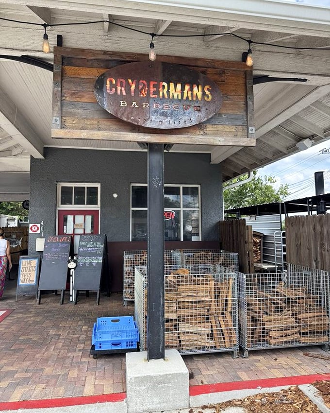 Crydermans Barbecue's rustic sign and wood stacks tell you they're serious about smoking. Authentic barbecue starts with real wood fire.