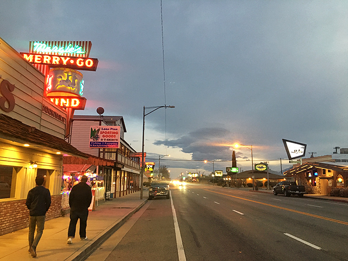 Lone Pine's main street comes alive at dusk with neon signs. The Merry-Go-Round's vintage glow beckons travelers on Highway 395.