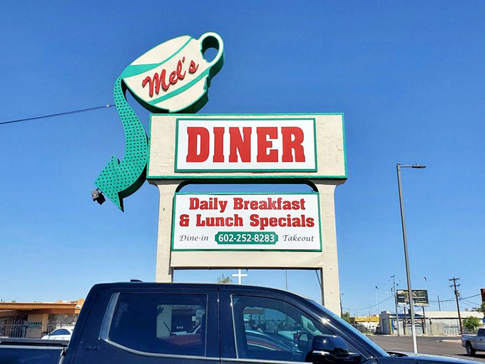 That giant coffee cup sign isn't just cute &ndash; it's a beacon guiding hungry souls to breakfast paradise at Mel's Diner.