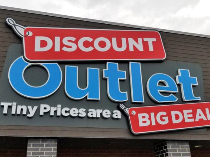 The Discount Outlet sign glows like a beacon for night owls seeking bargains. Even after dark, the deals shine bright!