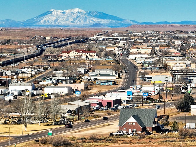 Snow-capped mountains tower over Winslow's desert landscape, creating that dramatic backdrop that makes Arizona postcards sell so well.