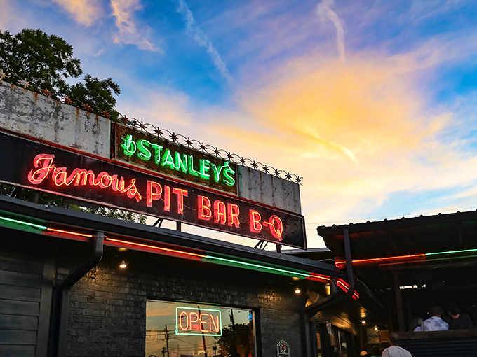 The neon glow of Stanley's sign against the twilight sky is a beacon for BBQ lovers. Follow the light to flavor paradise! 