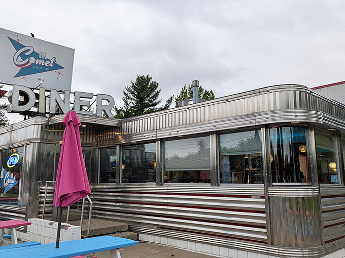 Classic Americana gleams in the Michigan sunshine. The Comet's stainless steel exterior and colorful picnic tables promise a time-traveling culinary adventure.