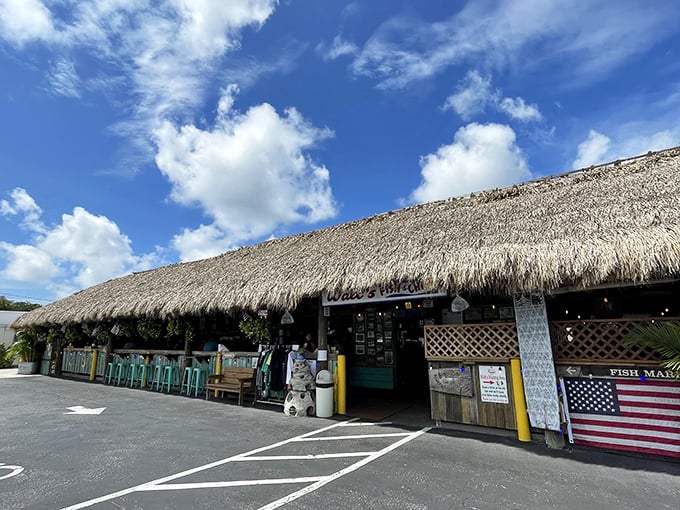 The thatched-roof entrance to Walt's Fish Market beckons like a tropical mirage in Sarasota, promising seafood treasures beneath its palm-frond canopy.