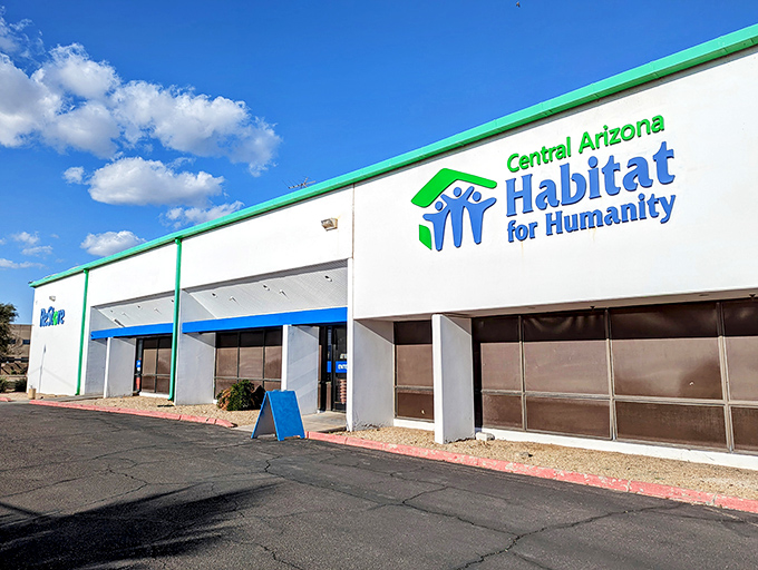 The white building with green trim and blue lettering stands like a beacon of bargain hope under the Arizona sky.
