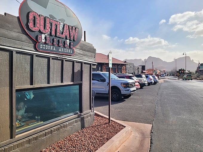 The iconic Outlaw Grill sign stands proudly against Sedona's majestic red rock backdrop, like a delicious mirage for hungry travelers.
