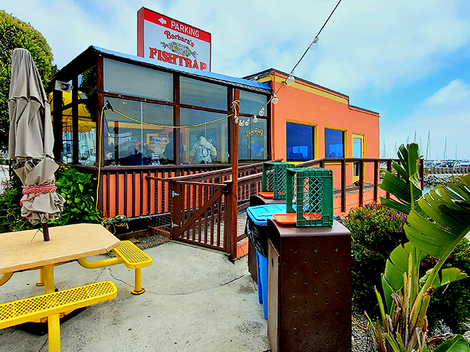 The vibrant red exterior of Barbara's Fishtrap stands out against the coastal sky, a beacon for seafood lovers seeking authentic maritime flavors.
