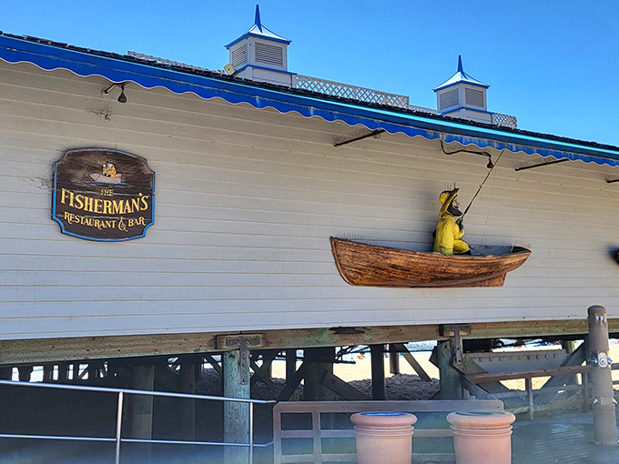That cheerful yellow fisherman isn't just decoration—he's announcing you've arrived at seafood paradise. The blue awning matches the ocean just steps away.