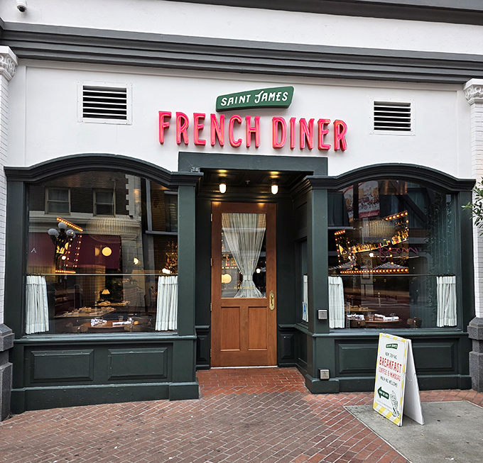 The red neon "FRENCH DINER" sign beckons like a lighthouse for the food-obsessed. Classic white brick exterior with green trim—understated elegance that promises authentic delights within.