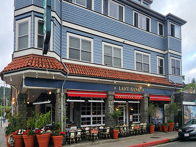 The striking blue exterior of Left Bank Brasserie with its signature red awnings instantly transports you to a Parisian street corner. Those flower pots aren't just for show!